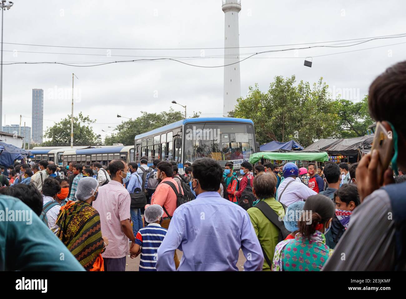 People gathered in the bus stand waiting for the bus with masks during ...