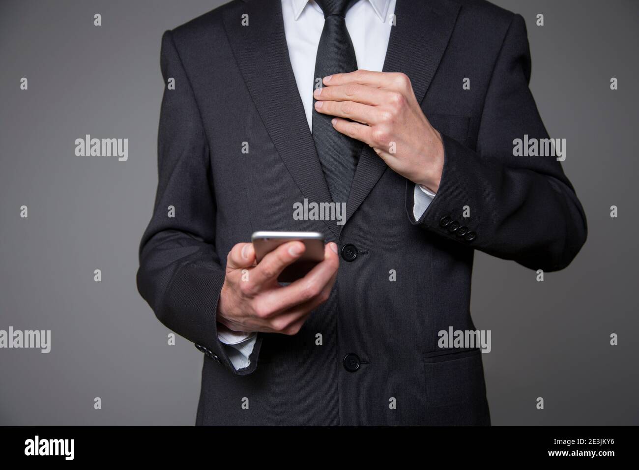 businessman wearing black suit using mobile phone Stock Photo - Alamy