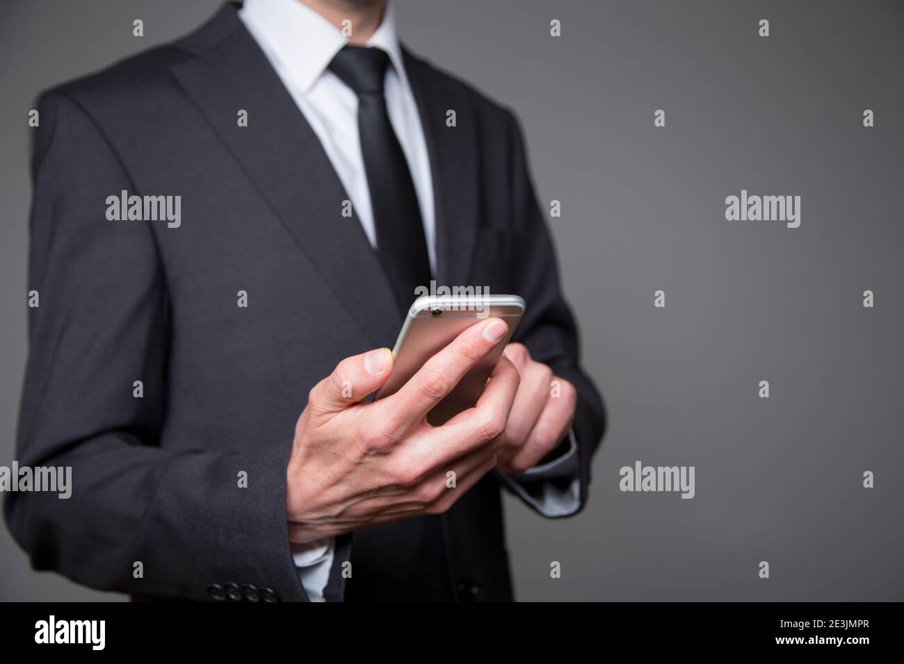 businessman wearing black suit using mobile phone Stock Photo - Alamy