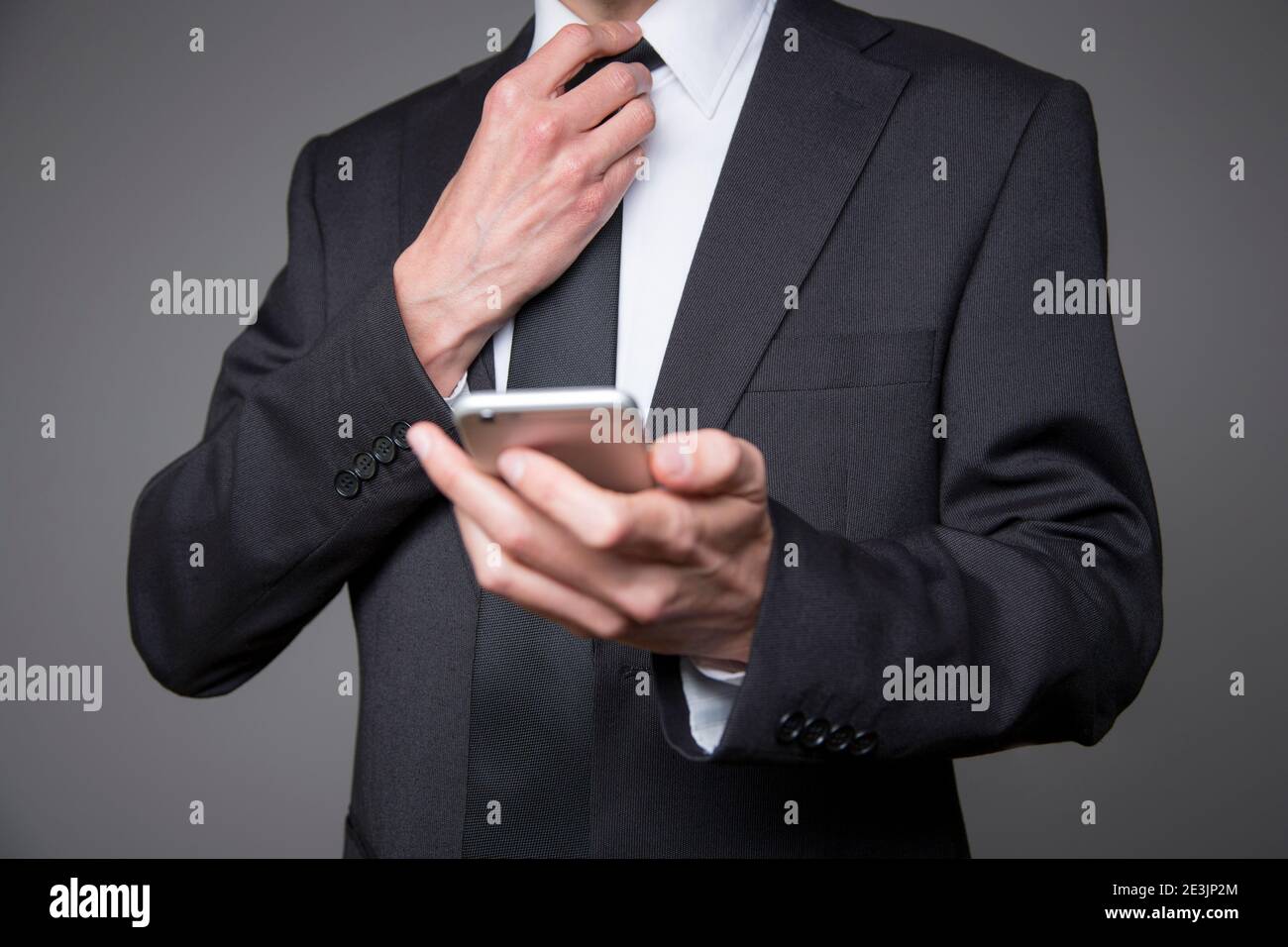 businessman wearing black suit using mobile phone Stock Photo - Alamy