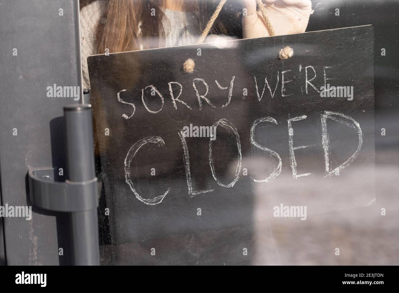 A waitress in a medical mask with closed sign Stock Photo - Alamy