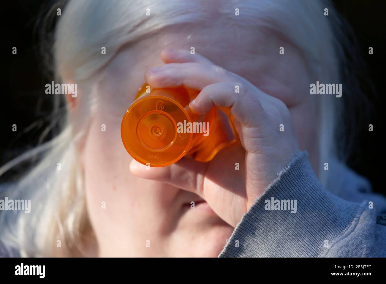 Woman looking desperately into an empty medication bottle Stock Photo ...