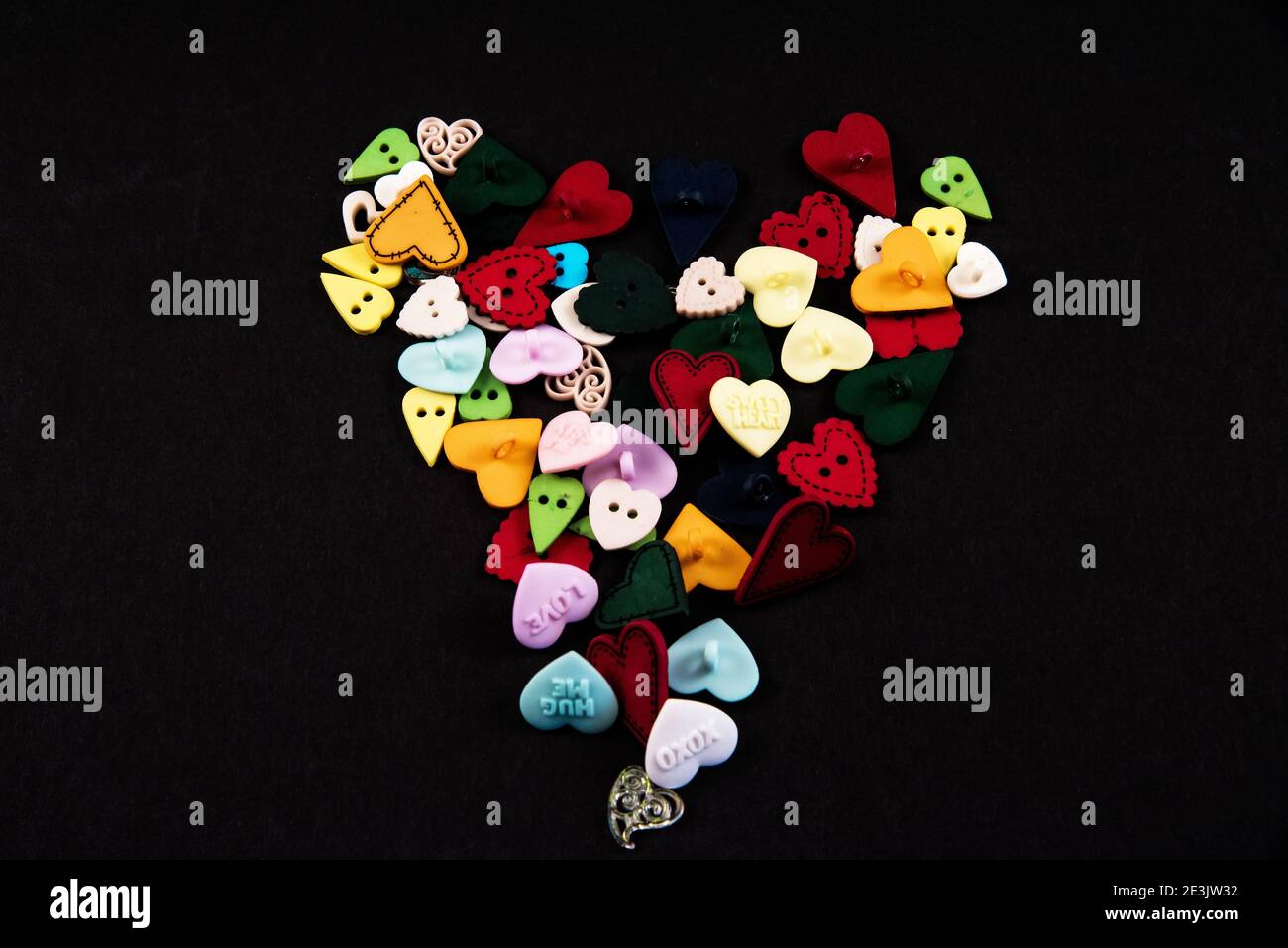 Heart shaped buttons on a black background Stock Photo - Alamy