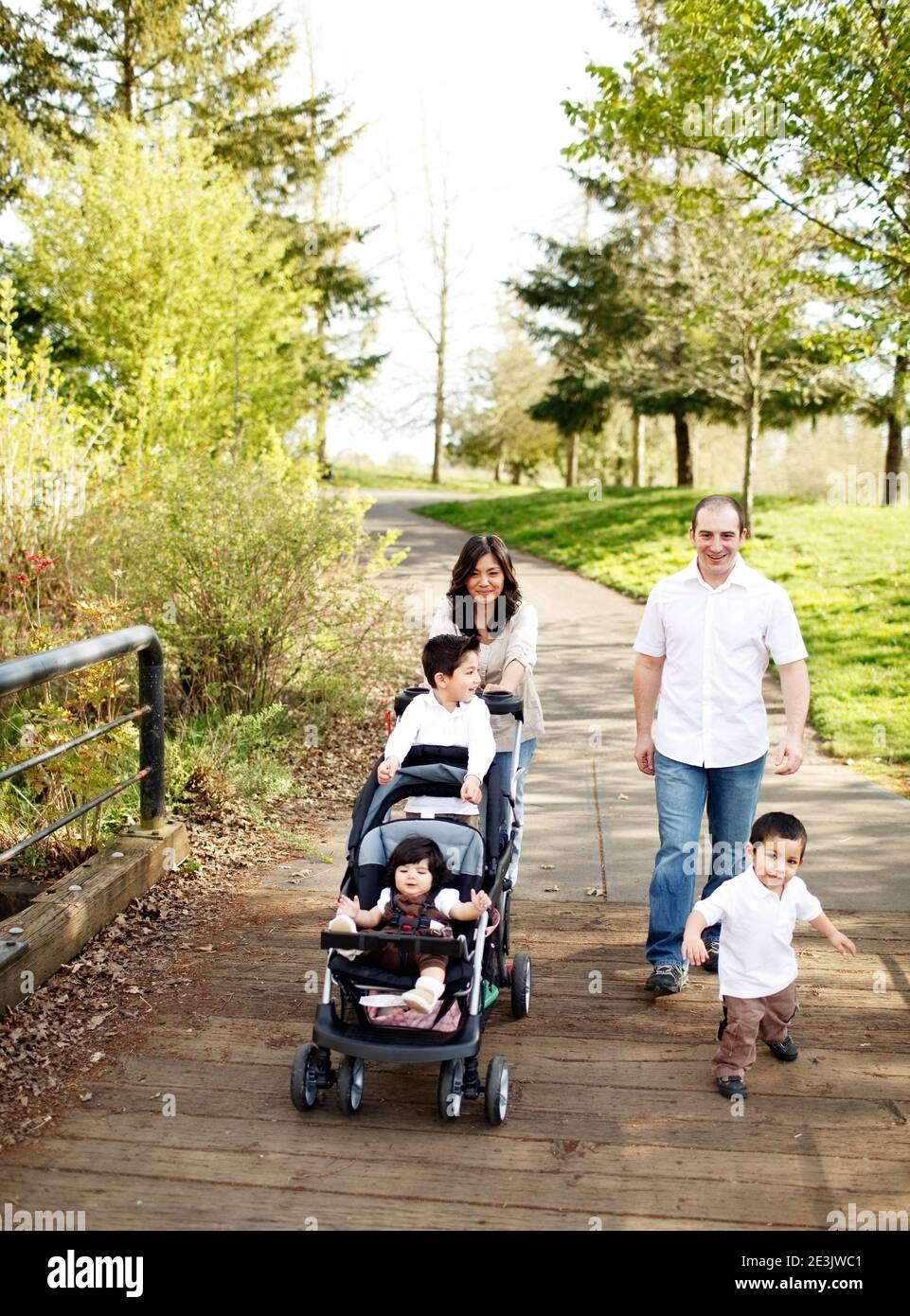 Family walking across park bridge Stock Photo - Alamy