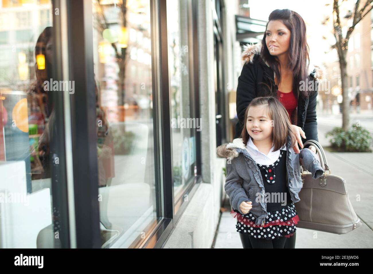 Mother and daughter window shopping in city Stock Photo - Alamy