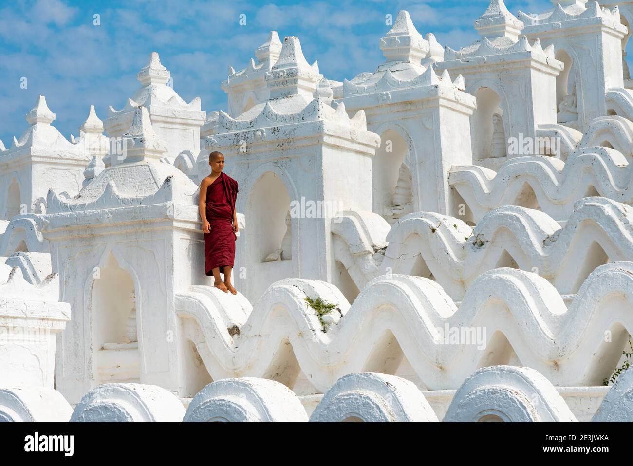 Novice monk standing at white Hsinbyume pagoda (also known as ...