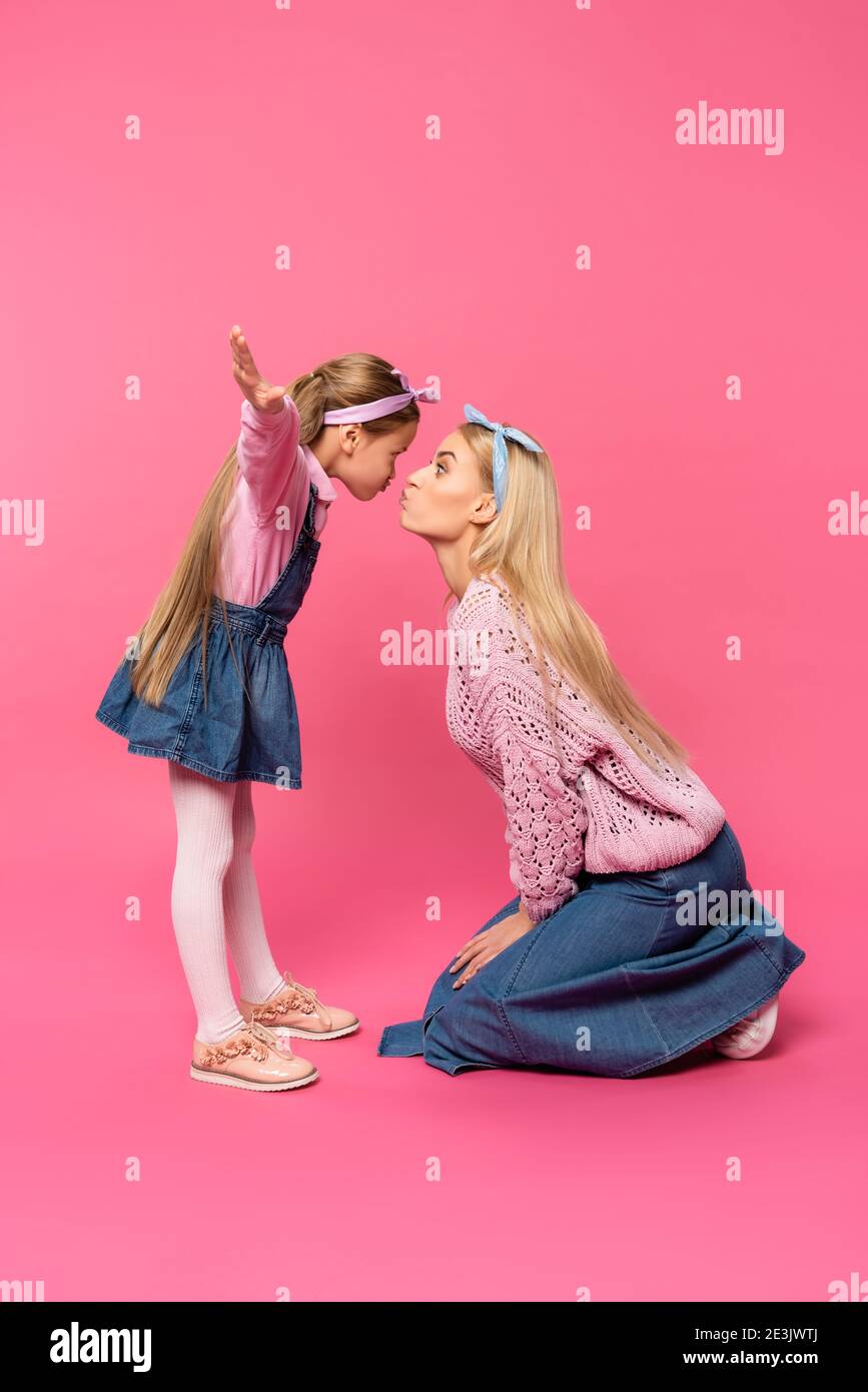 side view of kid puffing cheeks while standing with outstretched hands ...