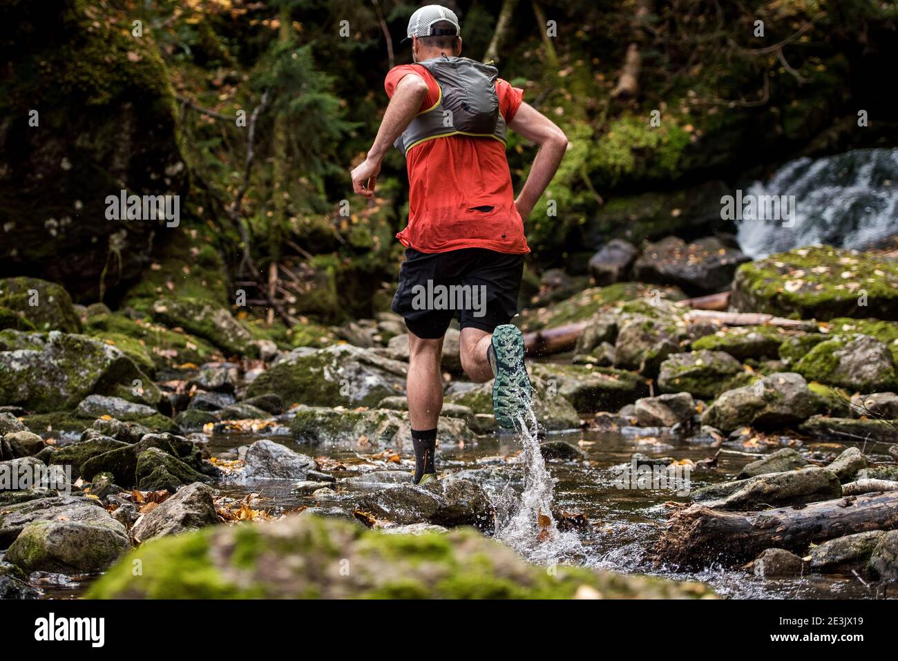 Man trail running and splashing through water Stock Photo - Alamy