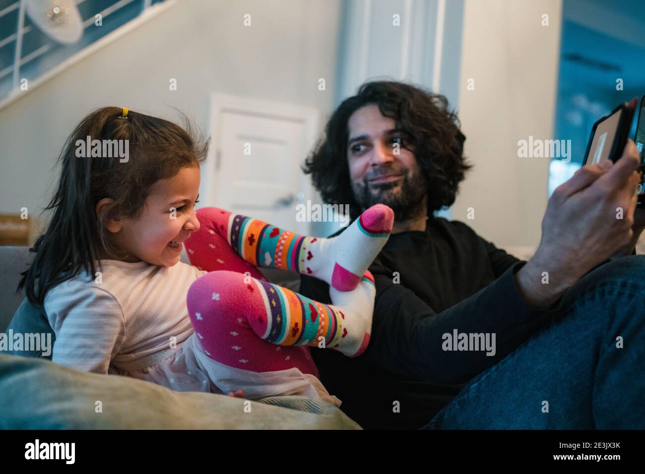 Father and daughter playing on iPad together and laughing Stock Photo ...