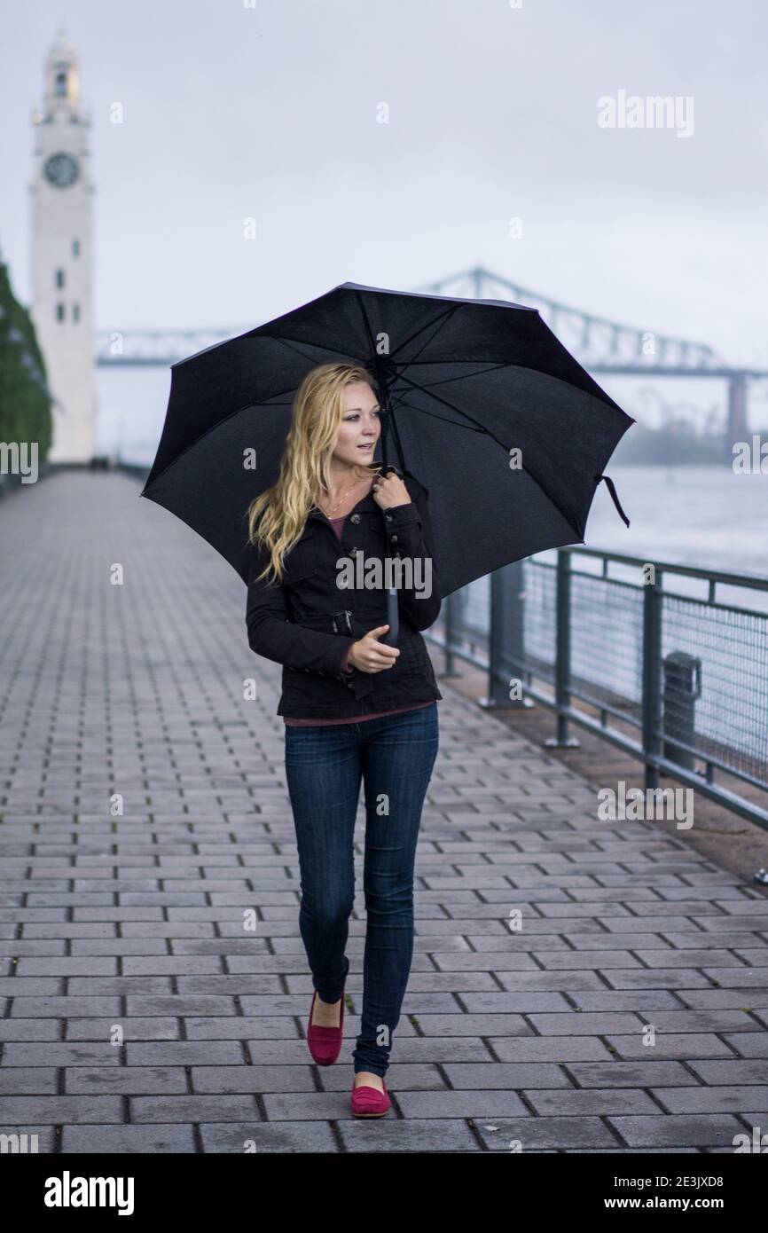 Beautiful blonde female hiding from rain in tourist district, Montreal ...