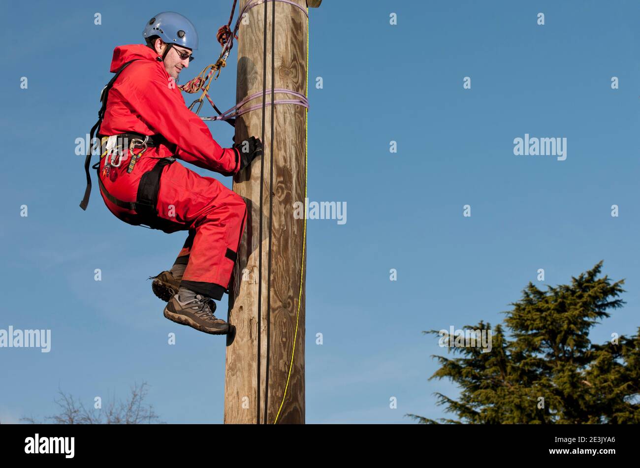 man ascending wooden pole at high rope training exercise Stock Photo ...