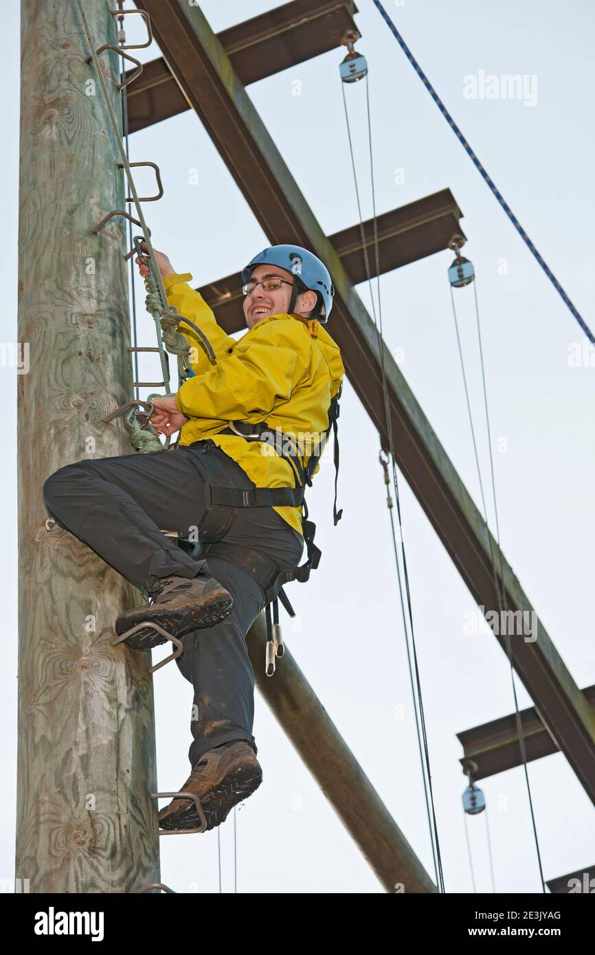 man ascending wooden pole at high rope training exercise Stock Photo ...