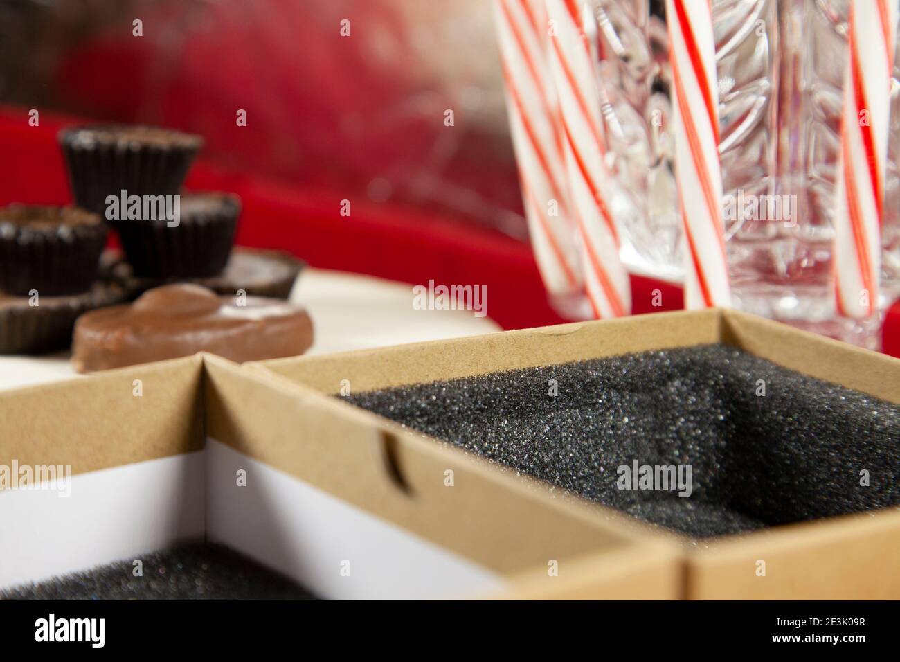 Empty, unwrapped gift box with candy canes and Christmas candies in the ...