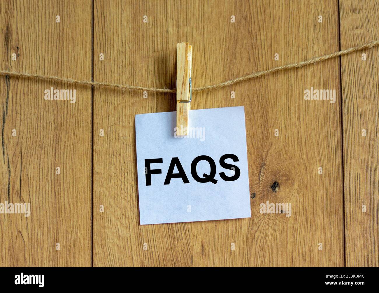 FAQS, frequently asked questions symbol. White paper on wooden ...