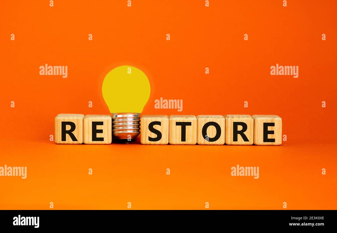 Restore symbol. Wooden cubes with the word 'restore'. Yellow light bulb ...