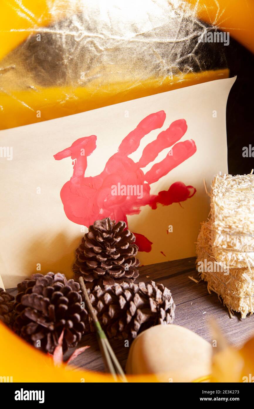 Red hand turkey on vanilla construction paper with hay and pinecones ...