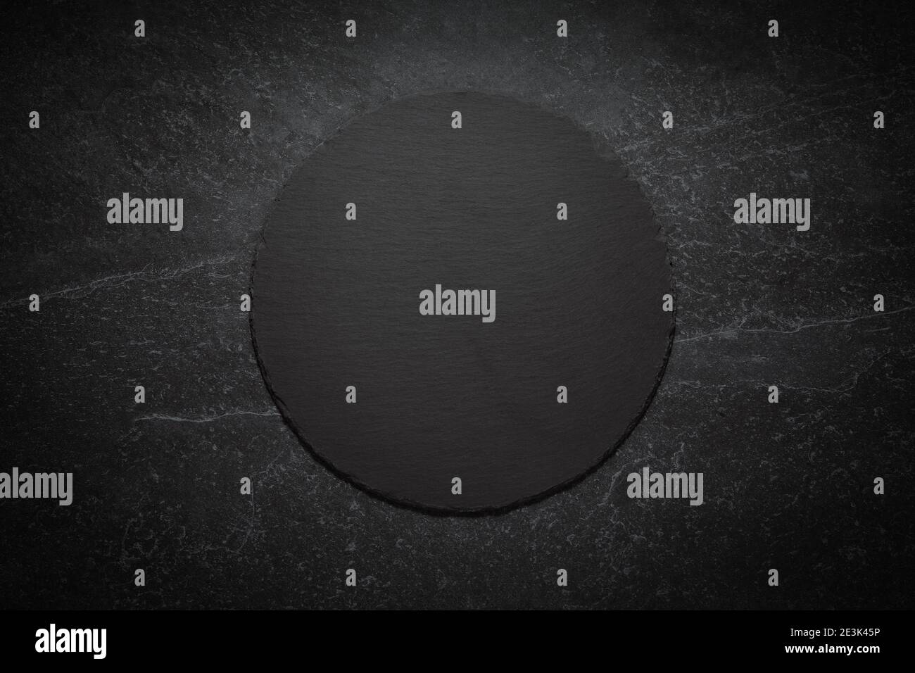 round black slate board on marble background, image with space for text ...