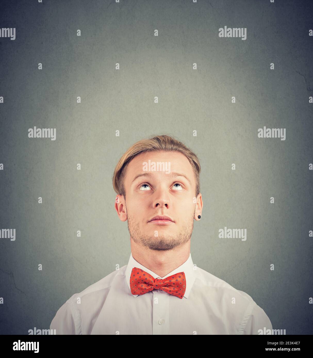 Portrait of a young man thinking looking up Stock Photo - Alamy