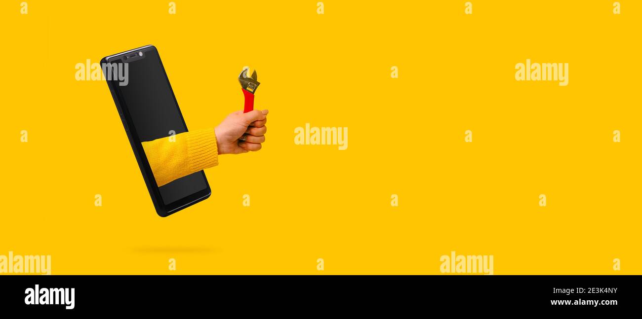 Hand holding adjustable wrench, sticking out of the smartphone screen ...