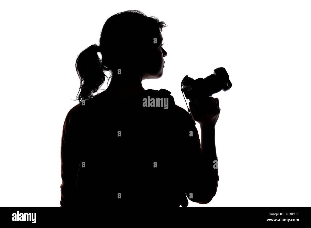 Backlit silhouette of a female photographer hiking and isolated on a ...