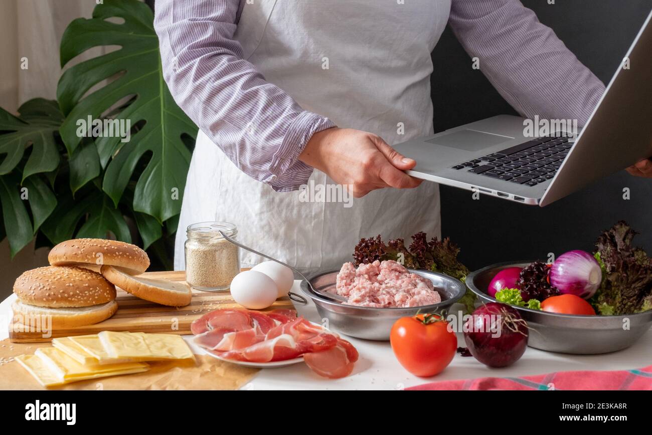 Female Chef cooking Big Burger or Cheeseburger and Using Laptop with ...