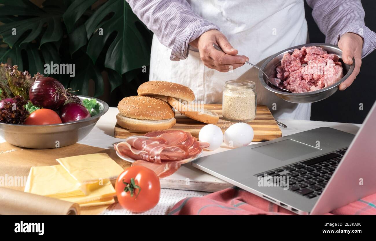 Female Chef cooking Big Burger or Cheeseburger and Using Laptop with ...