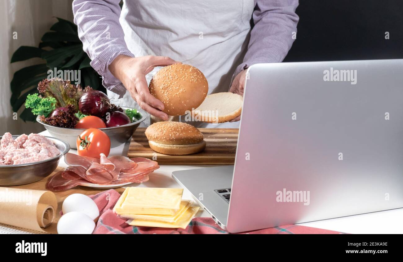 Female Chef cooking Big Burger or Cheeseburger and Using Laptop with ...