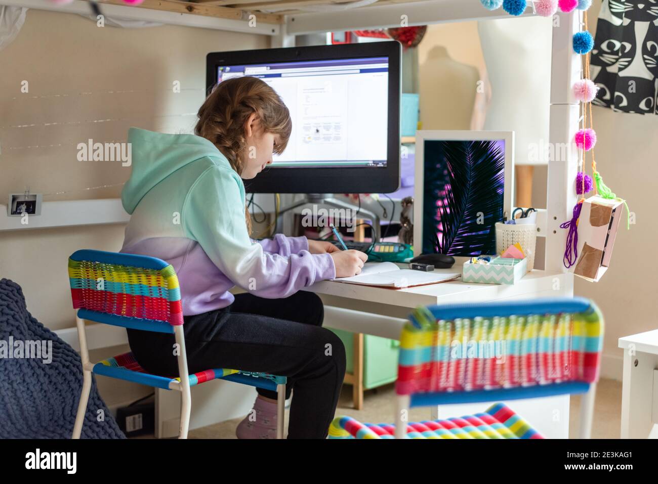 Young girl working at home during lockdown as children need to home ...