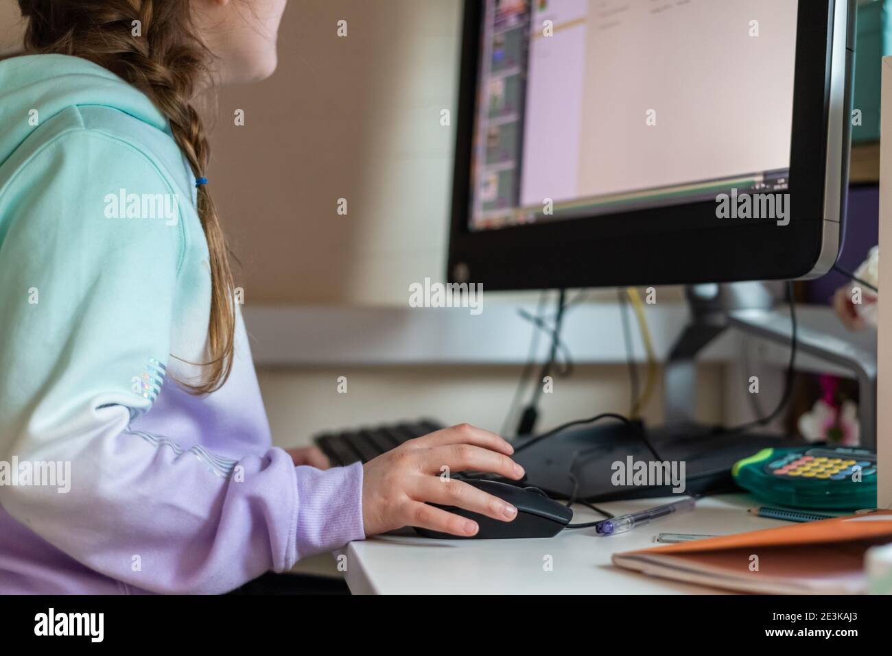 Child using a computer at home to do school work in a bedroom during ...