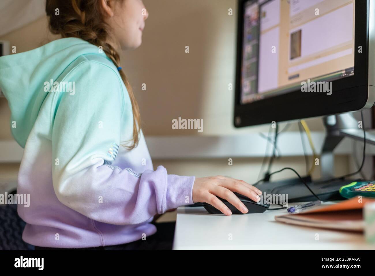 Child using a computer at home to do school work in a bedroom during ...