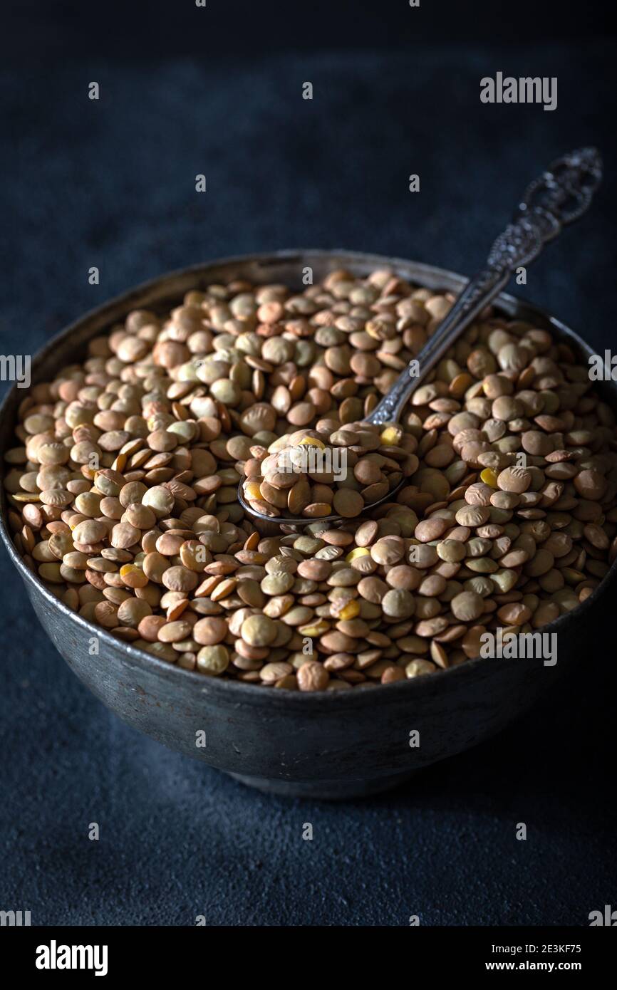 Green lentil in metal bowl on dark blue background Stock Photo - Alamy