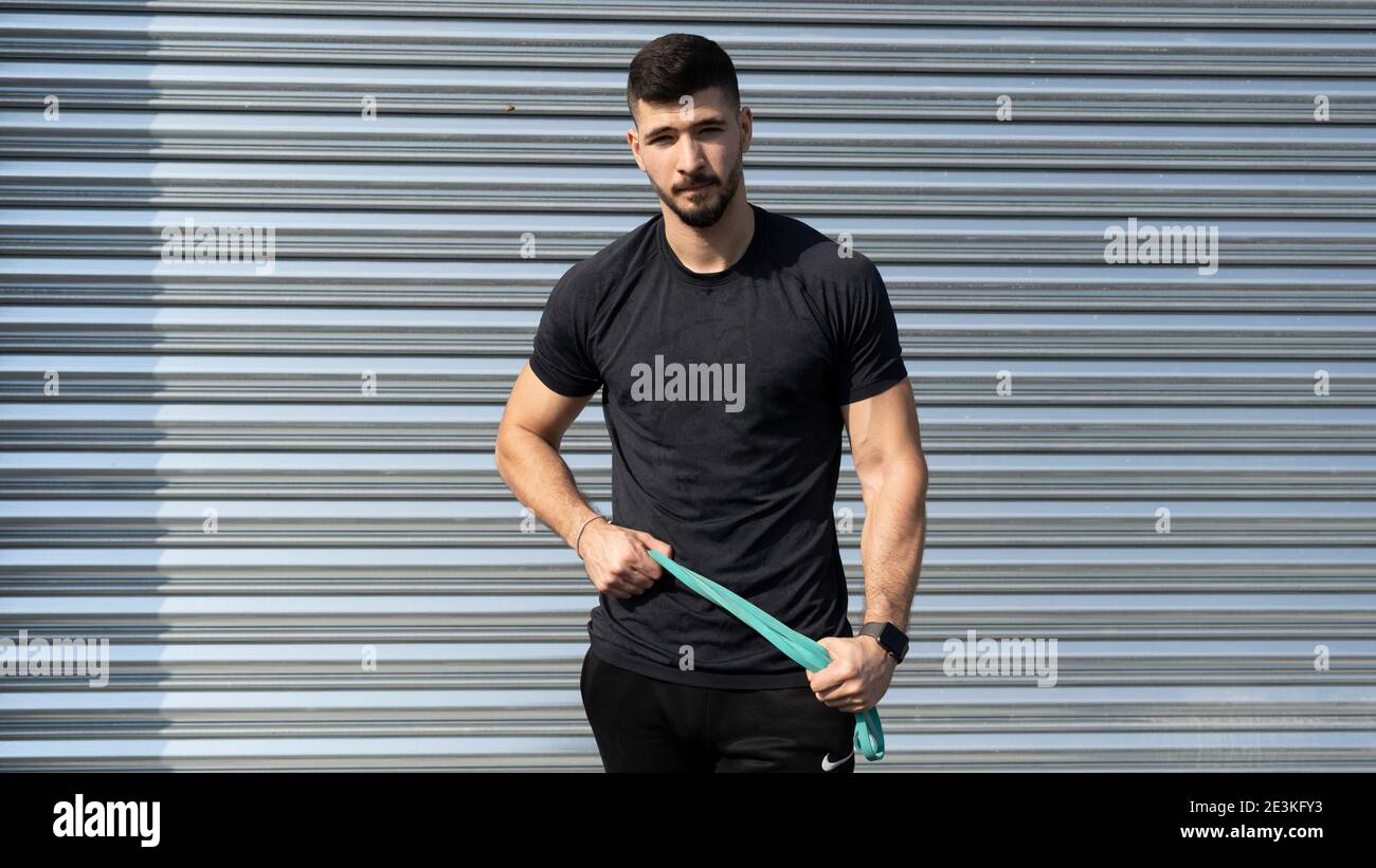 A young physical training instructor with a rubber band Stock Photo - Alamy