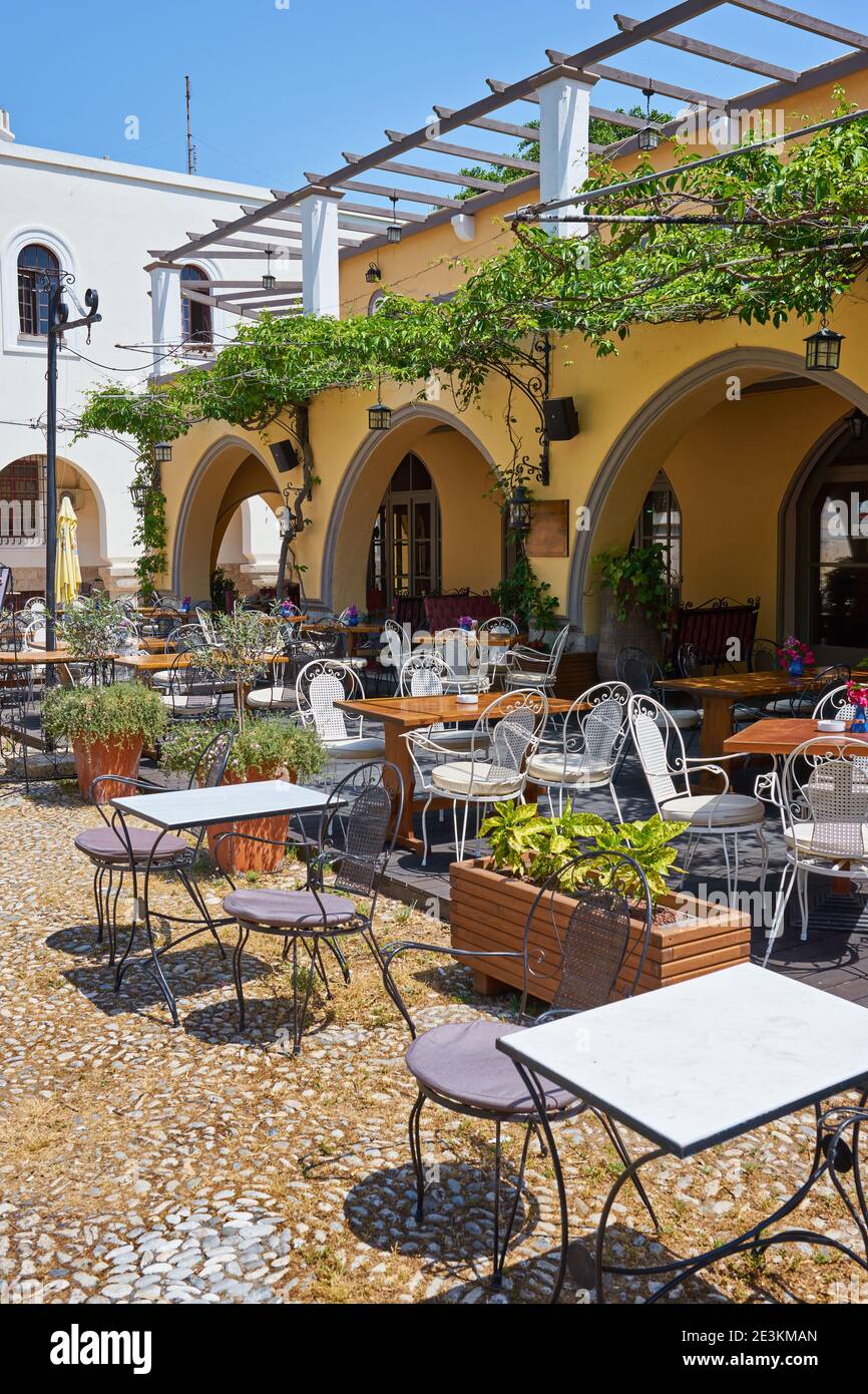 Traditional greek street cafe with flowers. Empty tables and chairs of ...
