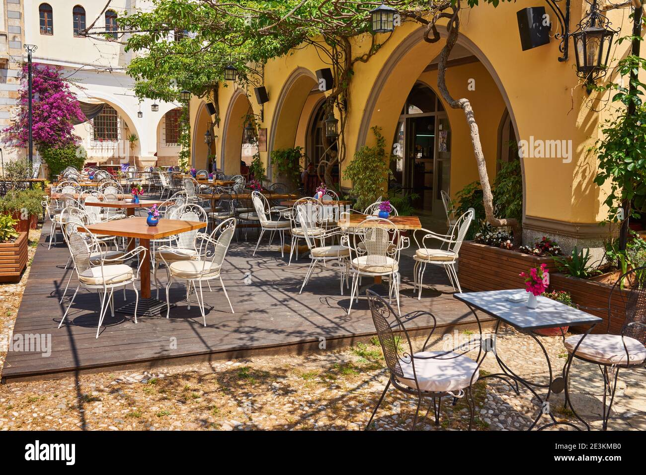 Traditional greek street cafe with flowers. Empty tables and chairs of ...