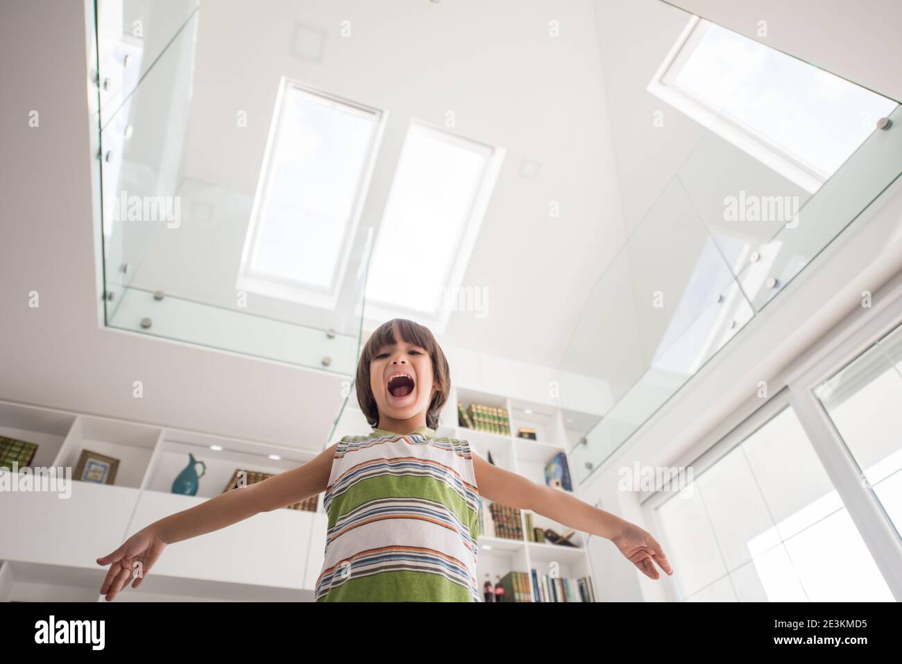 Happy kid at home with hands up Stock Photo - Alamy