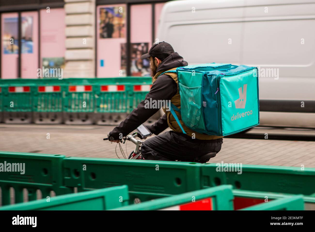 A Deliveroo courier rides along Piccadilly Circus delivering Takeaway ...