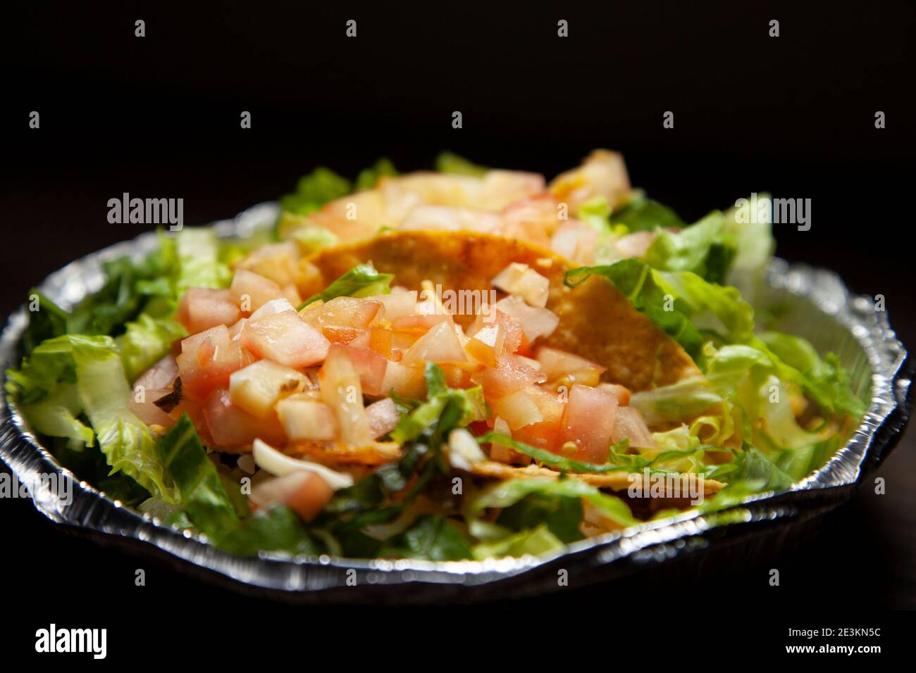 Tacos in a carry out tin with extra shredded lettuce and diced tomatoes ...