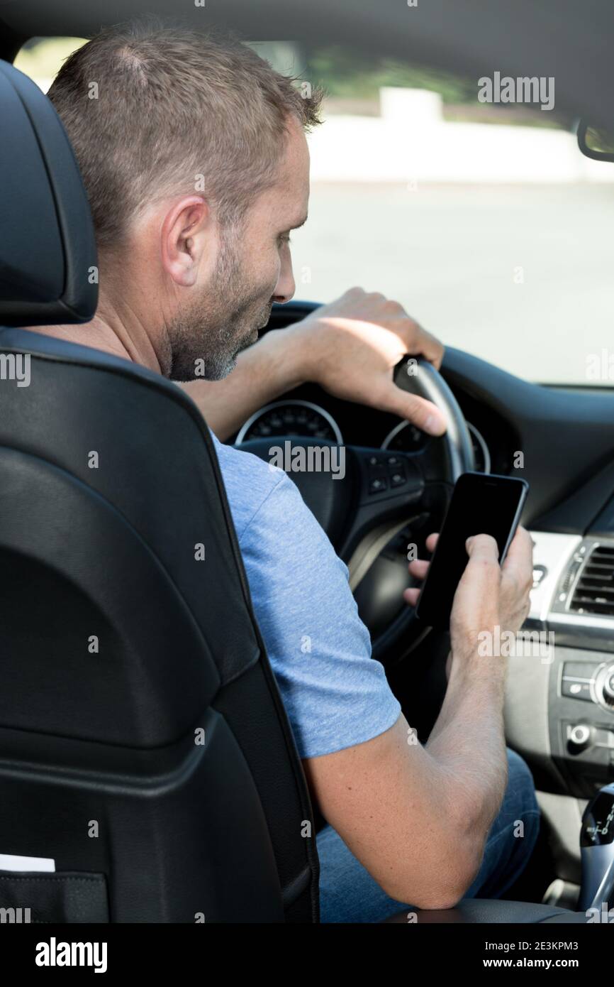 man sending a text while driving Stock Photo - Alamy