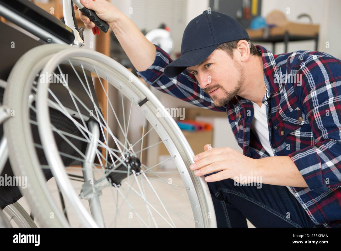 man is repairing a wheelchair at workshop Stock Photo - Alamy