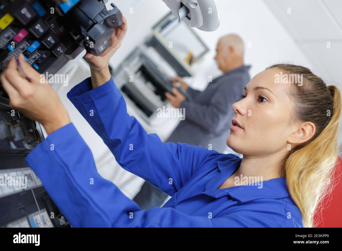 female apprentice fixing a printer Stock Photo - Alamy