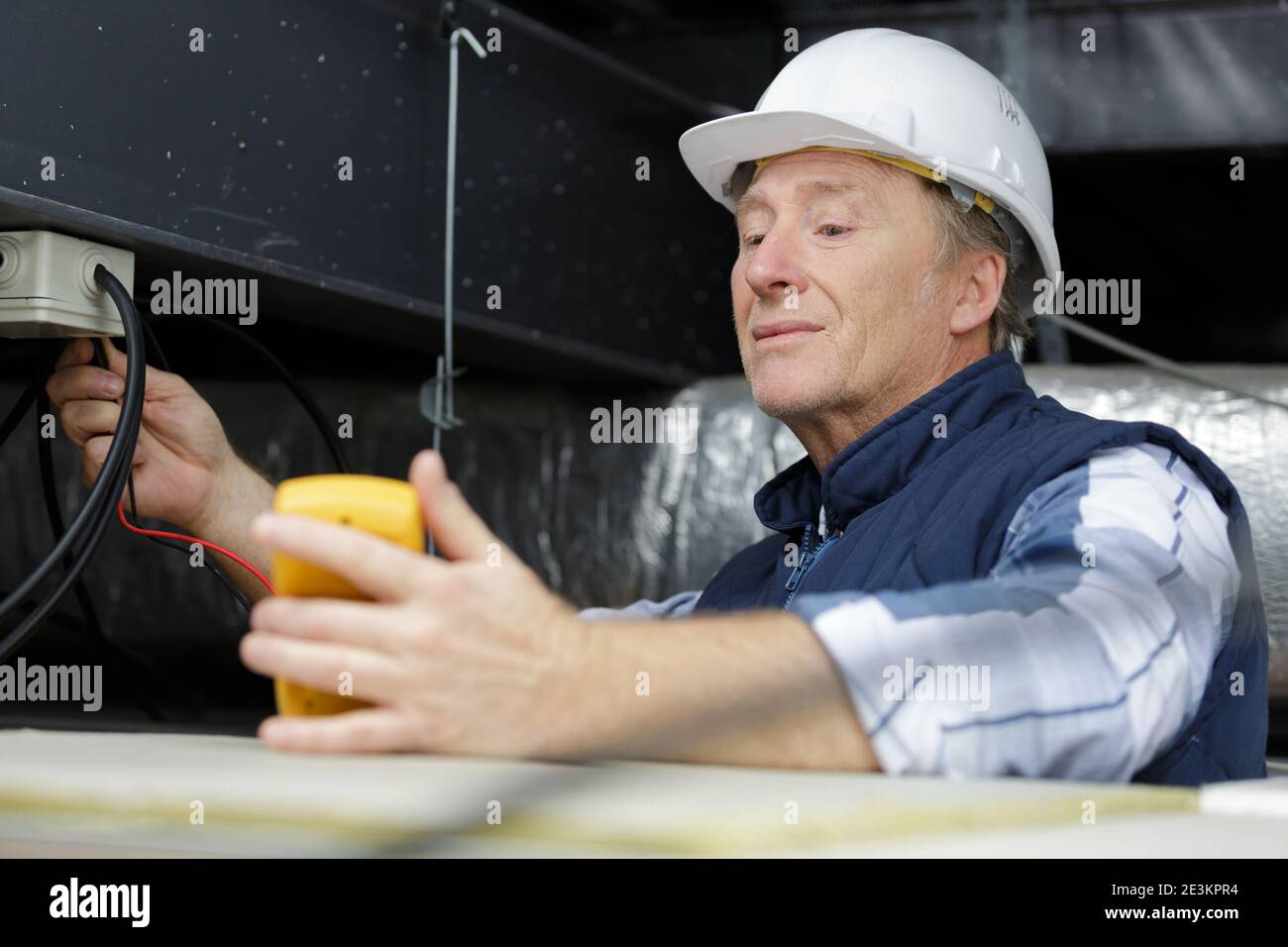 senior electrotechnician connecting wiring system Stock Photo - Alamy
