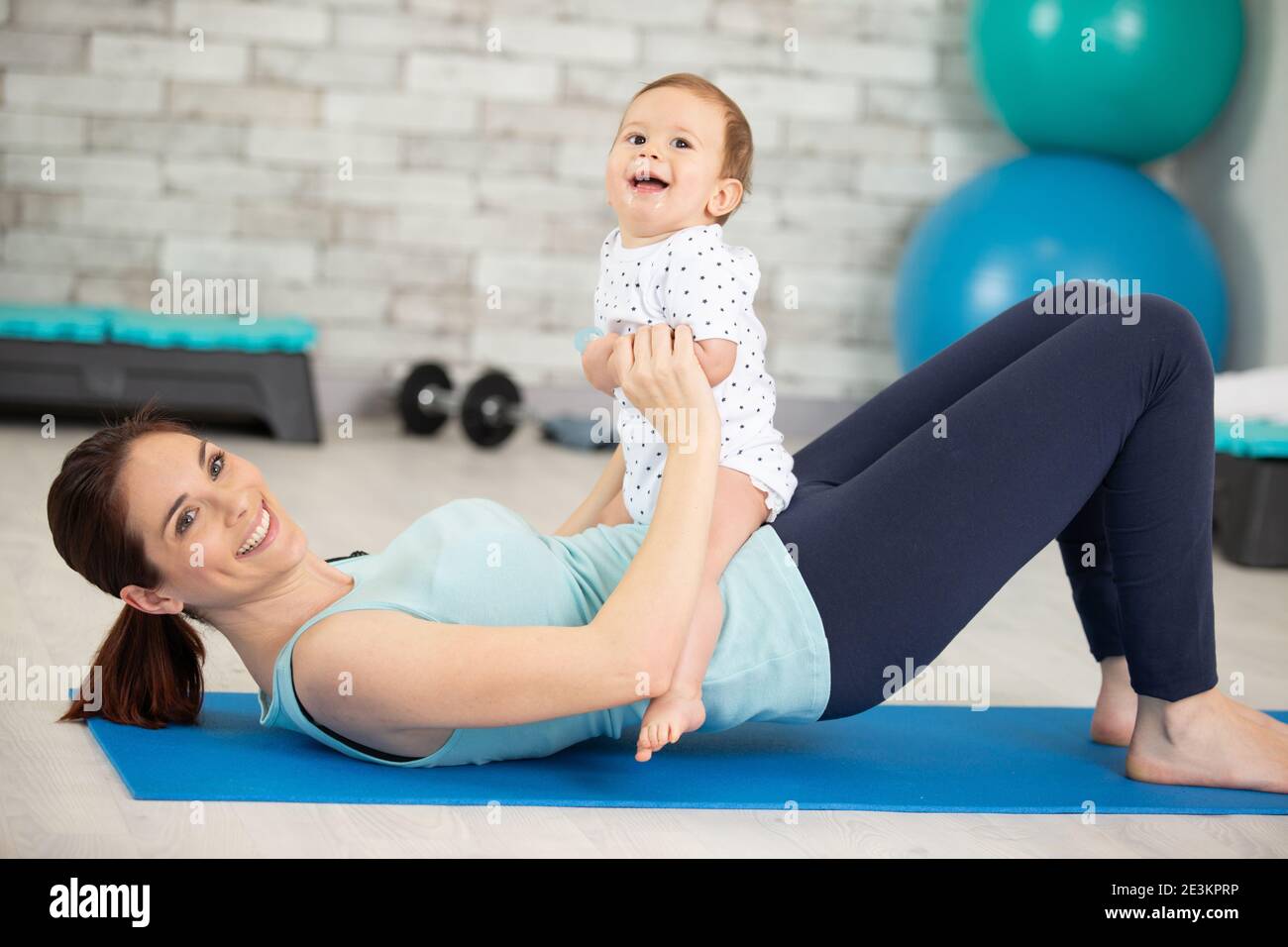 young mother does physical exercises with her baby Stock Photo - Alamy