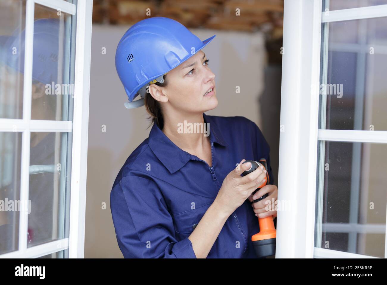 female worker is assembling metal-plastic window Stock Photo - Alamy