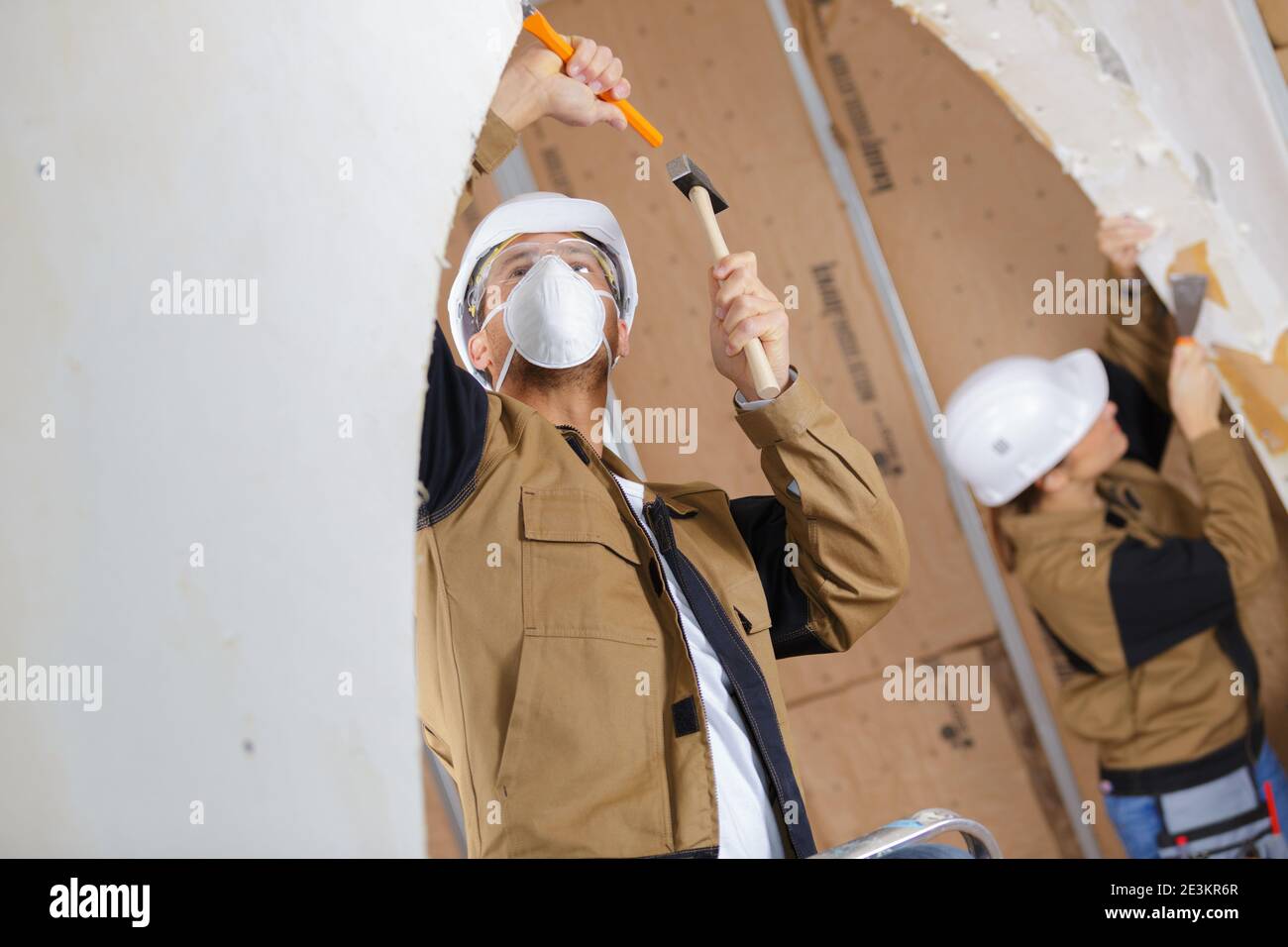 two builders working on interior arch with hammer and chisel Stock ...