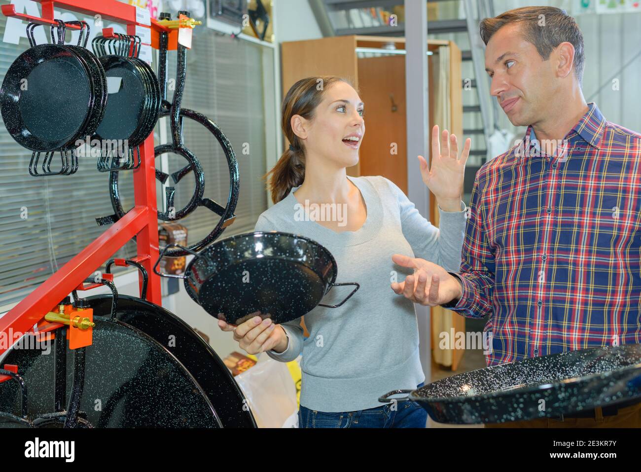 couple with frying pan in electronics store Stock Photo - Alamy
