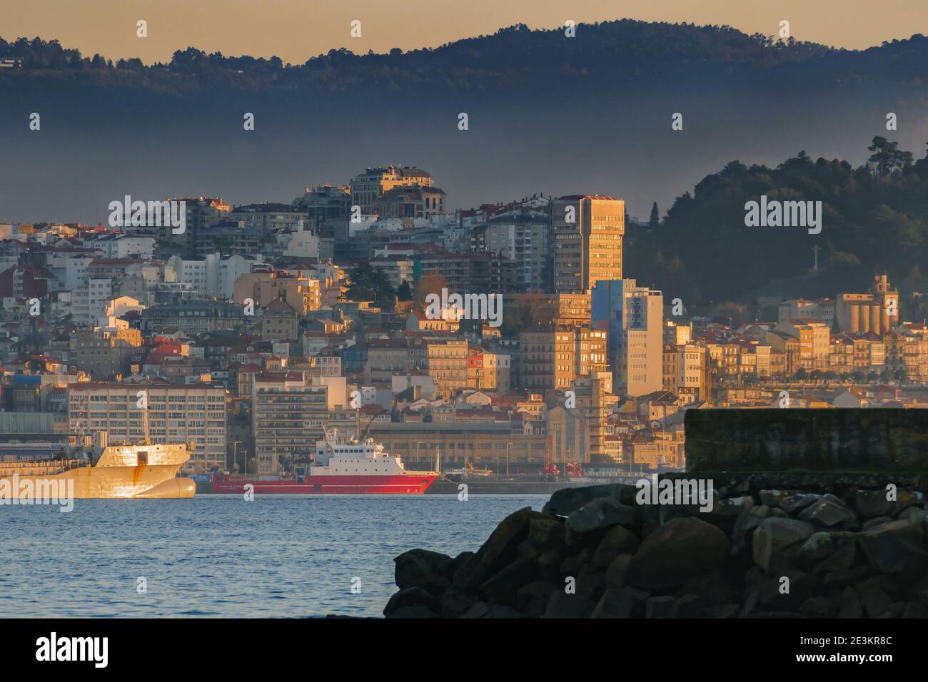 landscape of the city of vigo at sunset from a dock on the other side ...