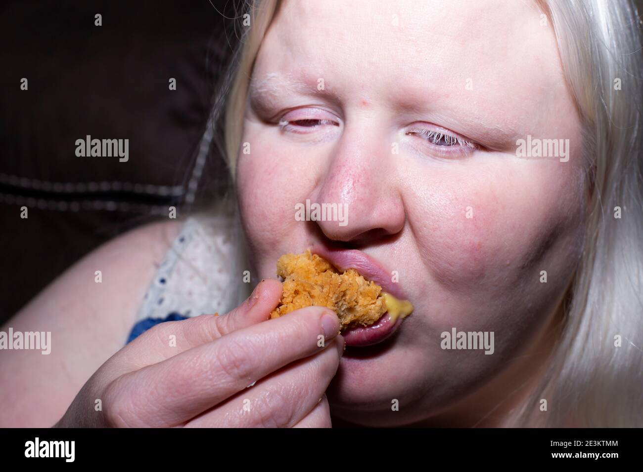 Obese, albino woman eating a chicken tender happily Stock Photo - Alamy