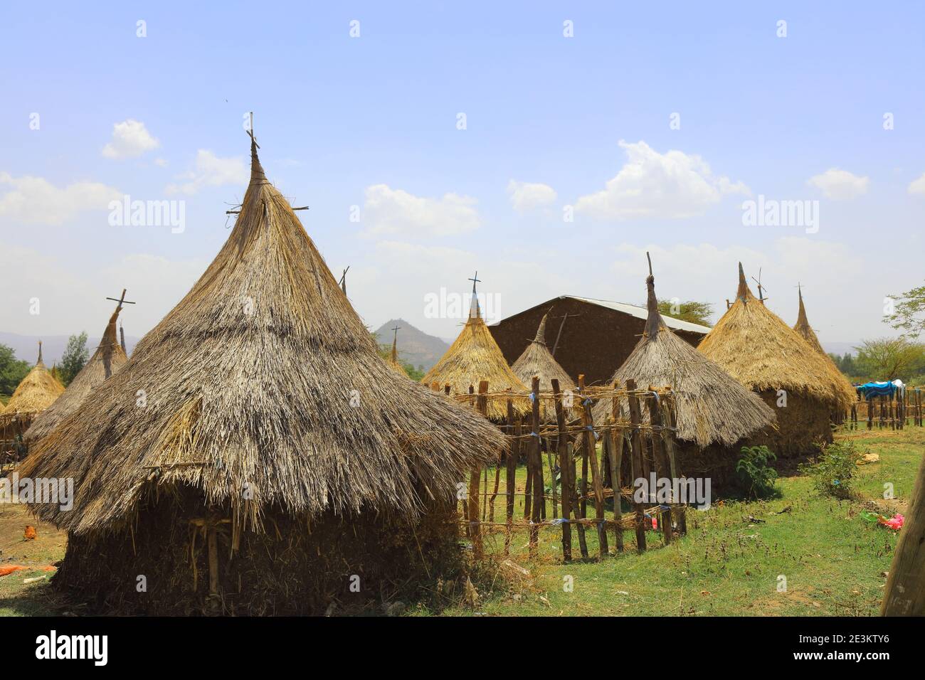 Small wooden huts with thatched roofs and twig crosses are the ...