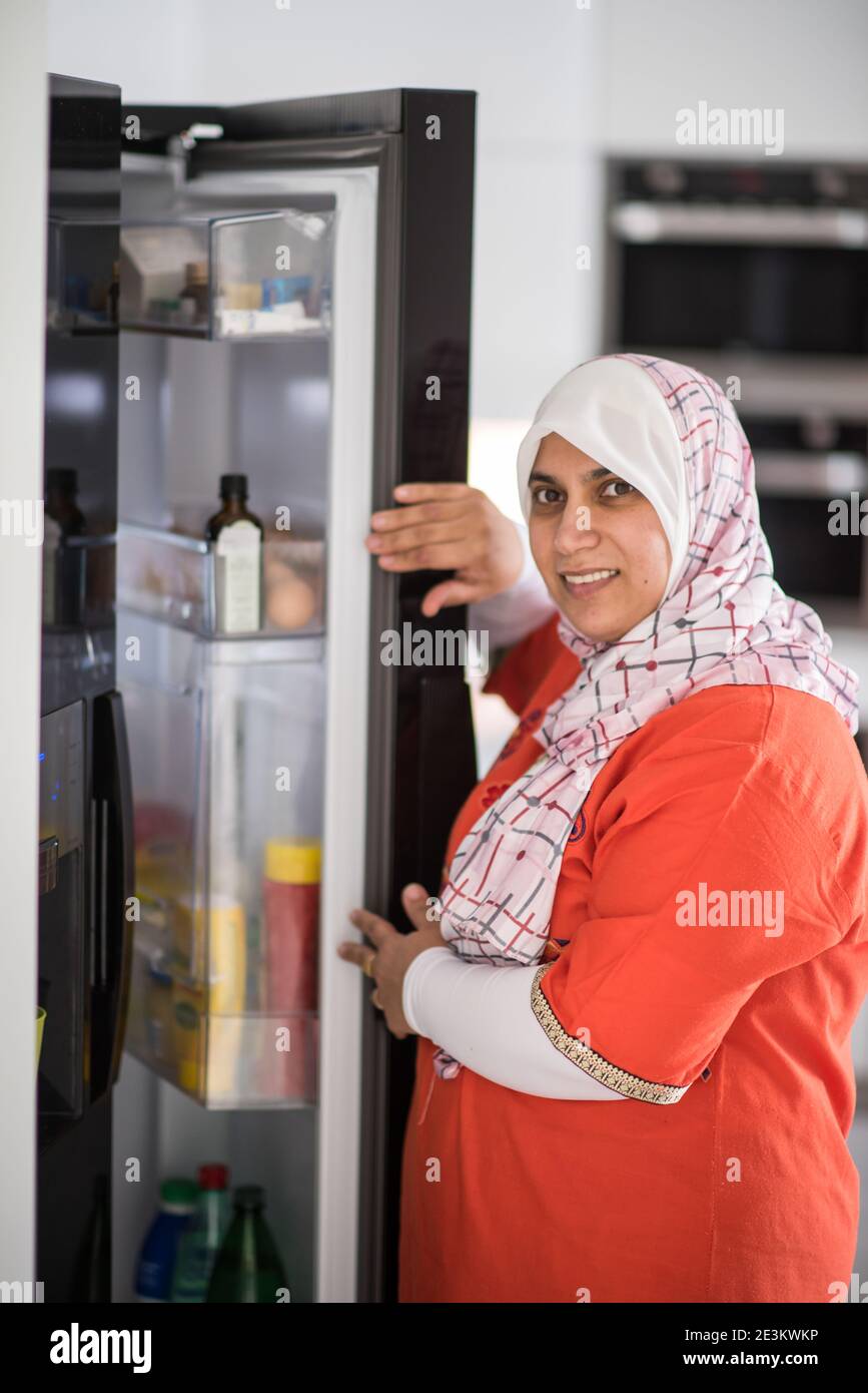Muslim Arabic traditional woman in kitchen preparing food for lunch ...
