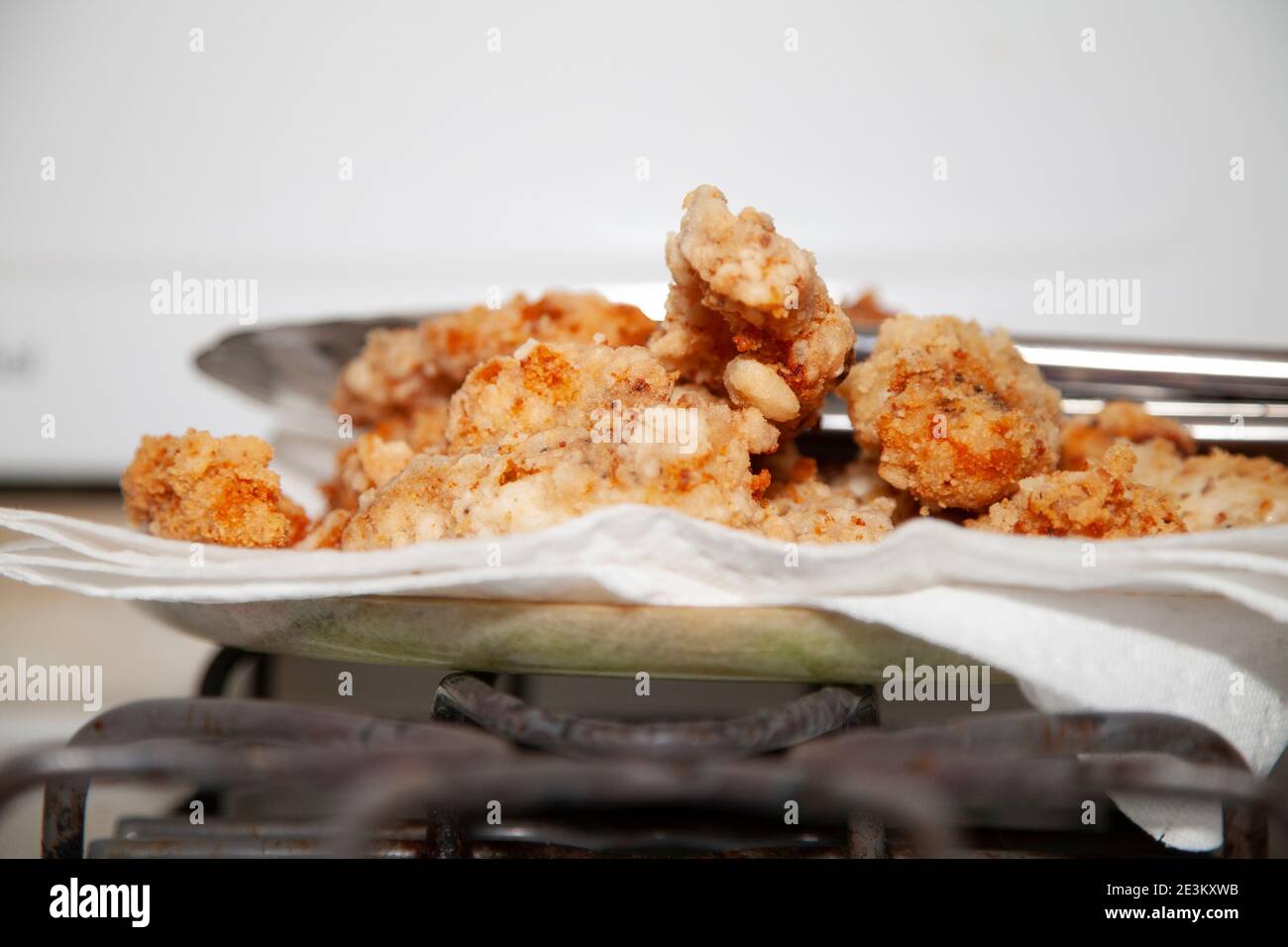 Homemade fried chicken strips and cooking tongs on a paper towel Stock ...